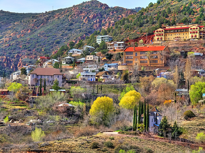 Jerome clings to Cleopatra Hill like a colorful barnacle on the hull of Arizona's history, its buildings seemingly defying both gravity and time.