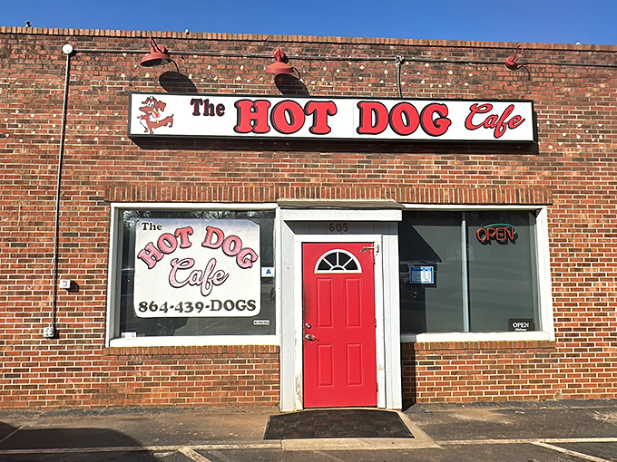 The bright red door of The Hot Dog Cafe beckons like a culinary lighthouse in Wellford, promising comfort food treasures behind that unassuming brick facade.