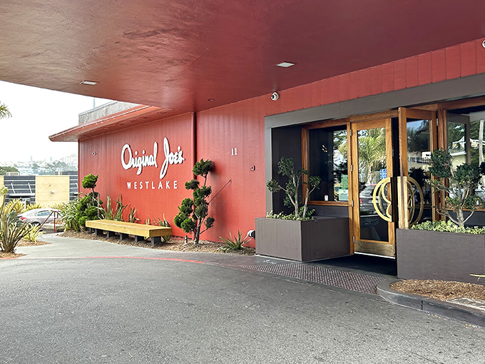 The coral-colored exterior of Original Joe's Westlake stands like a mid-century time capsule, promising culinary nostalgia before you even reach the door.