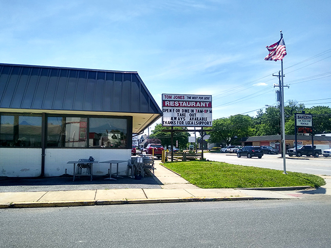 The unassuming exterior of Tom Jones Restaurant stands proudly under Pennsylvania skies, an American flag waving as if to signal "good food ahead!"