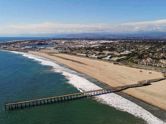 That pier stretches out like an invitation to simpler times, when beach days didn't require reservations.