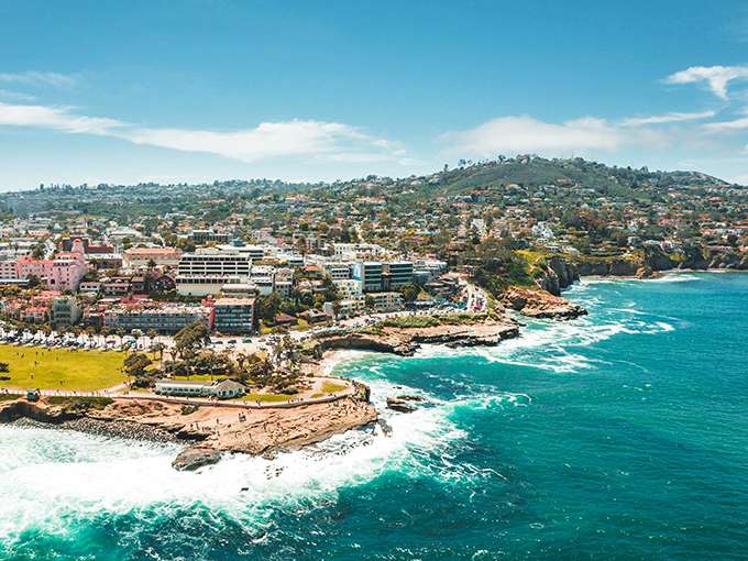La Jolla's coastline unfolds like nature's own IMAX experience, where Mediterranean-style buildings cling to cliffs above impossibly blue waters.