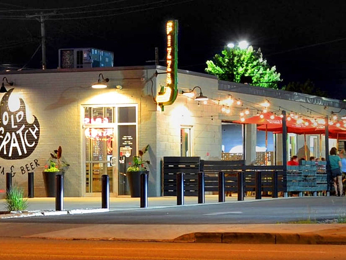 The unassuming exterior of Old Scratch Pizza belies the culinary magic happening inside. That flame logo isn't just for show&mdash;it's a promise of fire-kissed perfection.