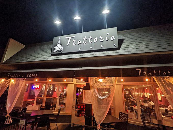 The warm glow of Trattoria Roma beckons from Grandview Avenue, its sheer curtains offering glimpses of Italian magic happening inside.
