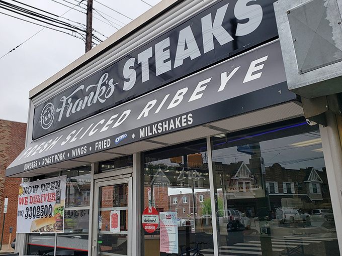 The iconic Frank's Steaks storefront beckons like a beacon of hope for the cheesesteak-deprived. That "FRESH SLICED RIBEYE" promise isn't just signage&mdash;it's a solemn vow.