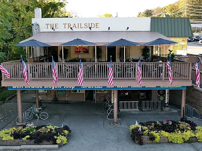 The Trailside's welcoming facade, complete with American flags and outdoor seating, beckons weary travelers like a culinary lighthouse on the Great Allegheny Passage.