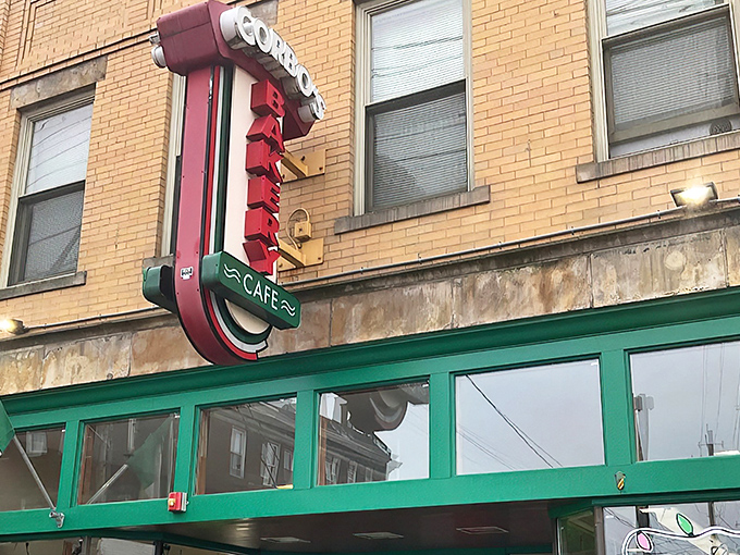 The iconic red and green vertical sign of Corbo's Bakery glows like a lighthouse for dessert sailors navigating the sweet seas of Cleveland's Little Italy.