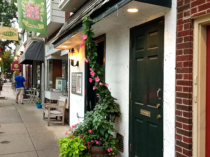 Summer blooms frame the entrance like nature's welcome committee, proving great food doesn't need flashy neon signs to announce its presence.