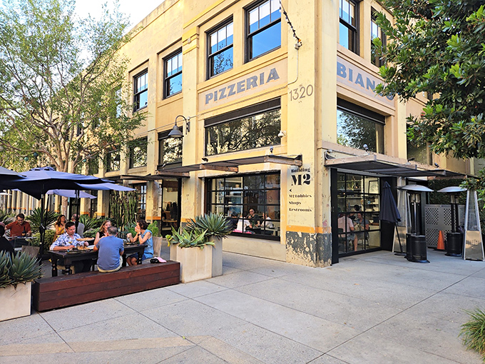 The unassuming exterior of Pizzeria Bianco stands like a culinary lighthouse in Row DTLA, beckoning pizza pilgrims with its simple "PIZZERIA" signage and string lights.