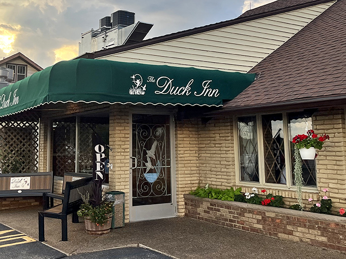 The emerald awning welcomes you like an old friend's embrace. Classic brick and thoughtful landscaping hint at the timeless experience waiting inside.