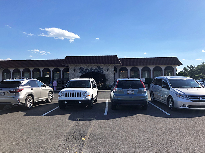 The stone facade and burgundy roof of Zoto's Diner stands like a culinary lighthouse, beckoning hungry travelers with the promise of comfort food excellence.