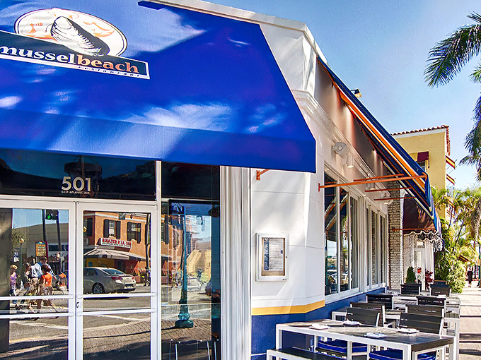 The iconic blue-and-white striped awning of Mussel Beach stands out on Atlantic Avenue like a maritime beacon calling seafood lovers home.