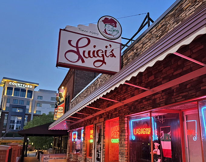 As night falls, Luigi's neon signs illuminate with a rosy glow, transforming this brick landmark into a nocturnal sanctuary for pasta pilgrims and pizza devotees.
