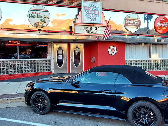 A time capsule on Main Street — a sleek sports car parked in front of Mom's Diner sets the scene, while its iconic black-and-white striped awning beckons with vintage charm and the promise of comfort food perfection.