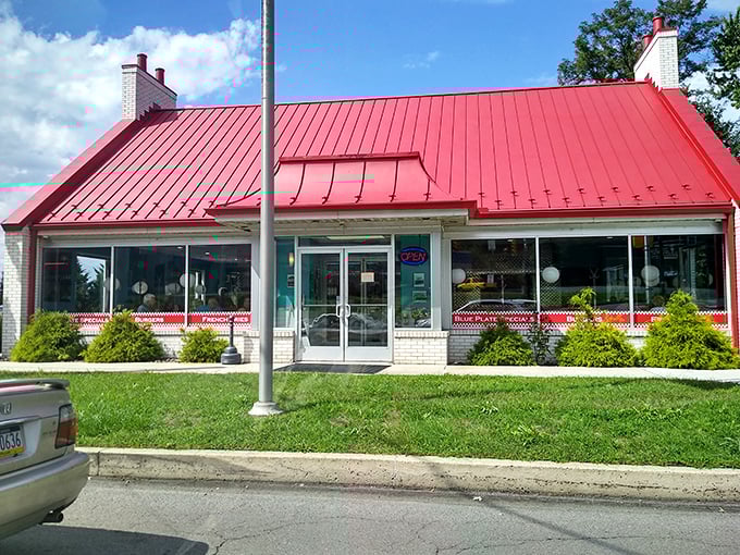 The iconic white brick exterior with its bold red trim and wide glass windows makes the entrance stand out like a beacon of breakfast hope.