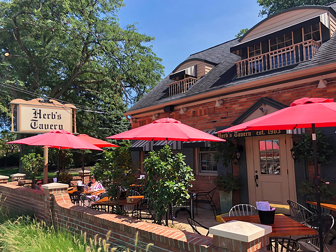 Herb's Tavern welcomes you with classic brick charm and cheerful red umbrellas &ndash; like finding a neighborhood gem you've been missing your whole life.