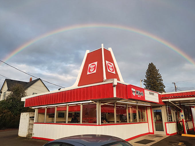 A rainbow arches perfectly over Mike's Drive-In, as if nature itself is pointing hungry travelers toward burger paradise.