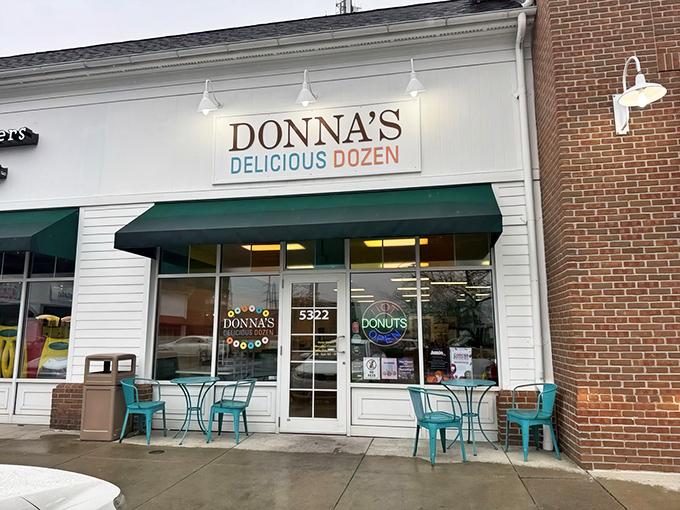 The unassuming storefront of Donna's Delicious Dozens beckons with its cheerful turquoise chairs and simple signage—proof that donut paradise often hides in plain sight.