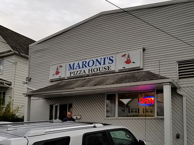 The unassuming white exterior of Maroni's Pizza House stands like a culinary lighthouse in Scranton, beckoning pizza pilgrims with its iconic blue signage and cartoon chef.