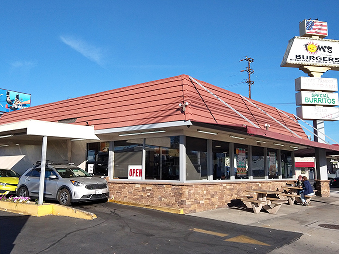 The iconic red roof and mint-green accents of Tom's Burgers 7 stand as a beacon of hope for hungry North Hollywood locals seeking breakfast salvation.