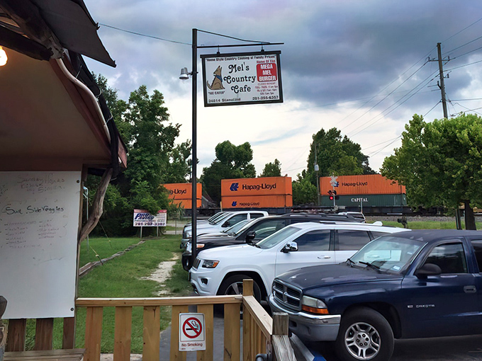 The humble roadside sign for Mel's Country Cafe stands like a beacon of hope for hungry travelers. Home of the legendary Mega Mel Burger!