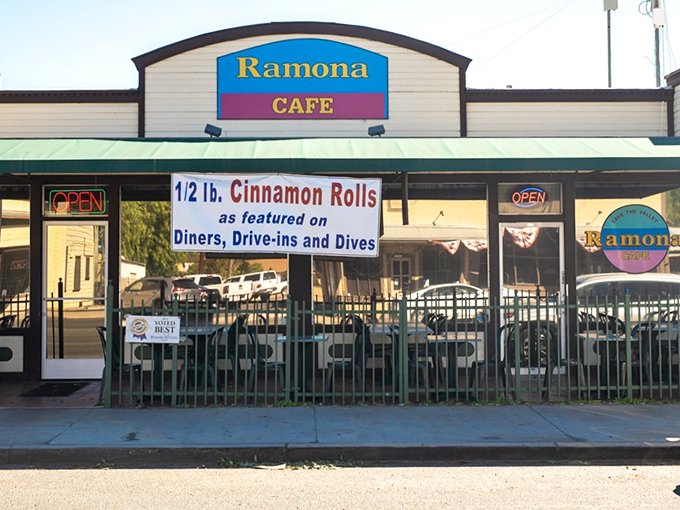 The unassuming exterior of Ramona Cafe, where that famous sign promising half-pound cinnamon rolls is your first clue that calorie-counting stops here.