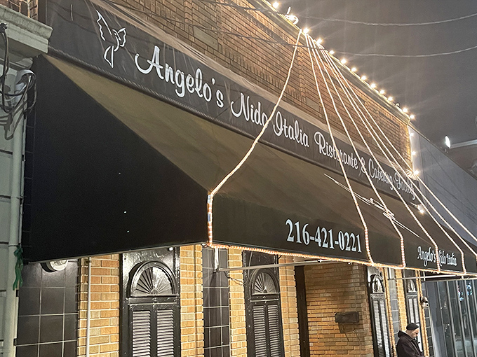The unassuming brick exterior of Angelo's Nido Italia beckons like an old friend, promising culinary treasures behind its classic awning and modest fa&ccedil;ade.