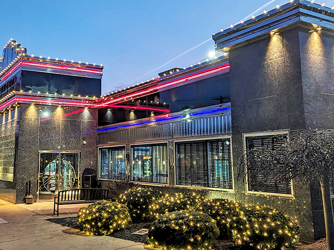 The Collegeville Diner glows like a neon-trimmed beacon at twilight, promising comfort food magic within its distinctive blue-gray walls.