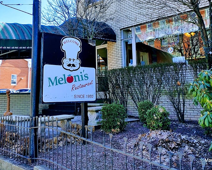 The iconic Meloni's sign welcomes hungry visitors with its mustachioed chef logo, a beacon of Italian comfort in Uniontown since 1950.