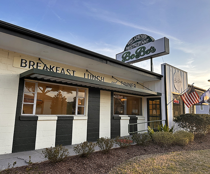 The classic black and white exterior of BoBo's Fine Chicken stands like a beacon of comfort food promise in Virginia Beach, complete with American flag proudly waving.