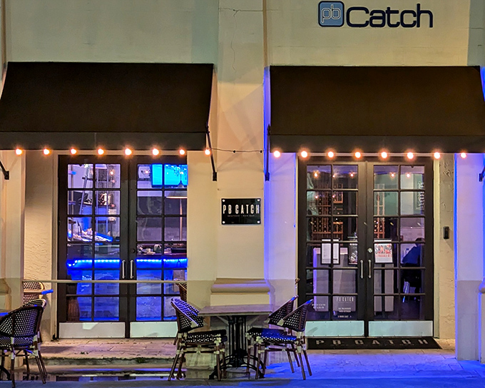 PB Catch's elegant exterior beckons with subtle charm, its warm lighting promising seafood treasures within. Palm Beach sophistication without the pretension. 