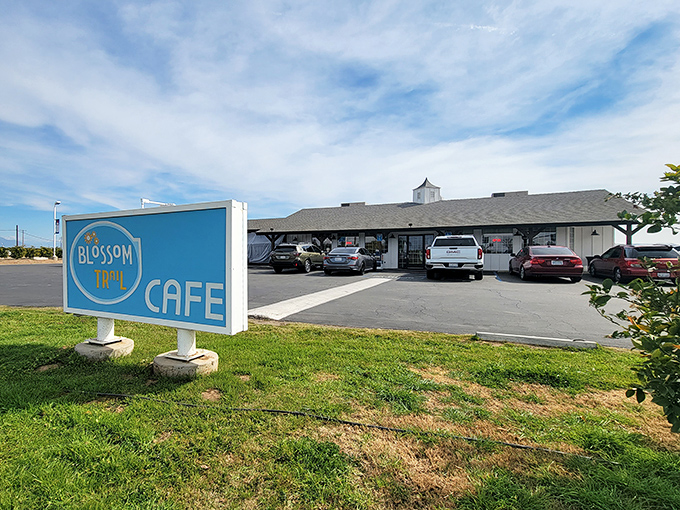 The cheerful blue sign welcomes hungry travelers like a beacon of breakfast hope along the rural highway. California sunshine included at no extra charge!