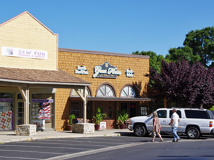 The warm glow of Guest House Grill's exterior beckons like a lighthouse for hungry travelers. String lights twinkle against wooden beams, promising comfort within.