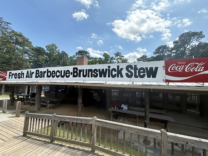 The iconic Fresh Air Barbecue sign stretches across the humble wooden structure like a beacon of smoky promise to hungry travelers on Georgia backroads.