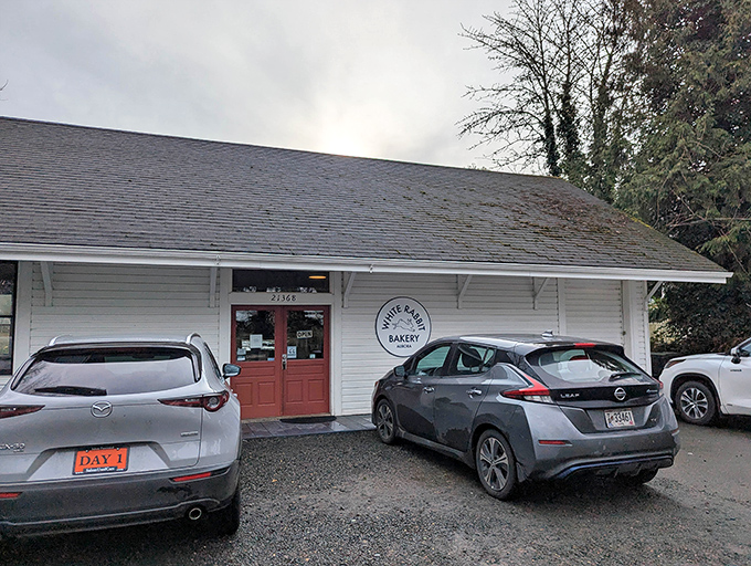 The unassuming white exterior with its cheerful red door is like a storybook cottage that happens to house pastry perfection instead of woodland creatures.