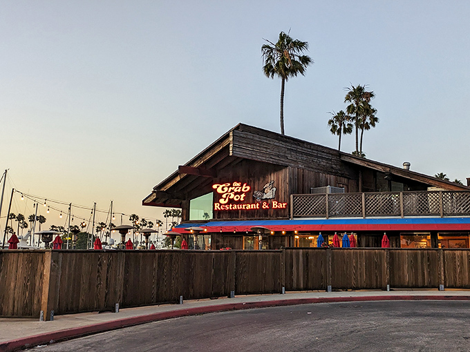 The Crab Pot's weathered wooden exterior and iconic red signage stand like a maritime beacon against the California sky, promising seafood treasures within.