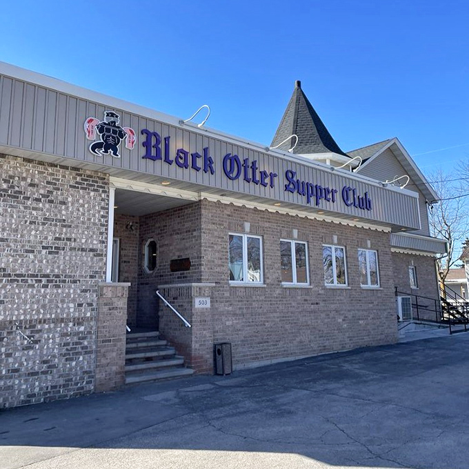 The iconic brick facade of Black Otter Supper Club beckons hungry travelers with its vintage sign and warm glow&mdash;Wisconsin's version of a culinary lighthouse.