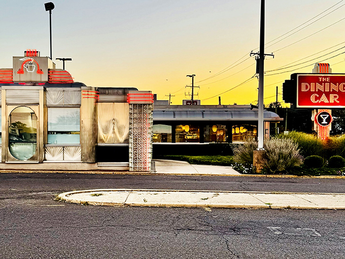The Dining Car's gleaming stainless steel exterior glows at sunset, a beacon of comfort food promising that everything inside will taste like childhood memories.