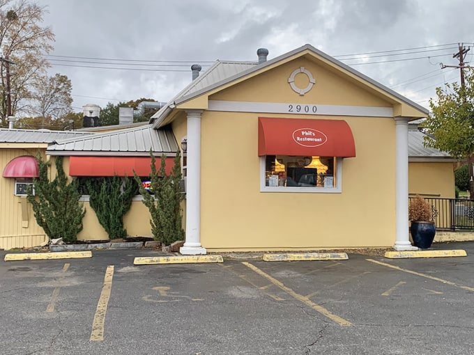 The iconic red awning of Phil's Restaurant beckons hungry travelers like a culinary lighthouse on Central Avenue in Hot Springs.