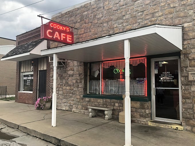 The stone facade and iconic red neon sign of Cooky's Cafe stands as a beacon of hope for hungry travelers on Missouri's rural highways.
