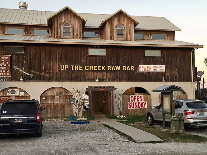 The weathered wooden exterior of Up The Creek Raw Bar stands like a salty sea captain, promising treasures of the Gulf within those humble walls.