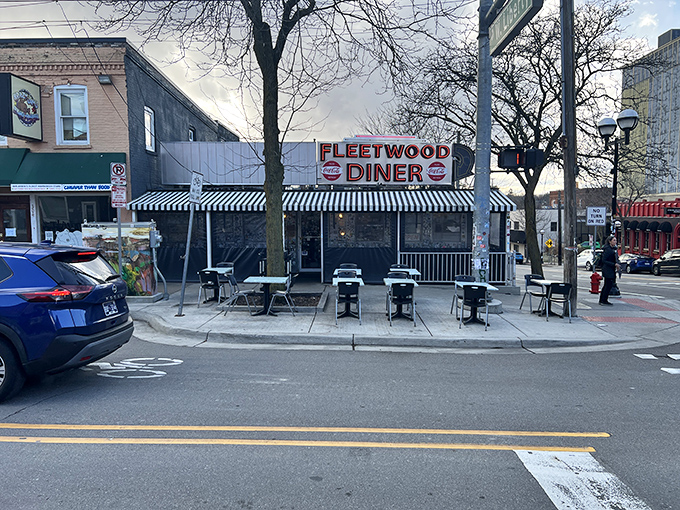 The silver exterior of Fleetwood Diner gleams like a beacon of hope for the hungry, its classic black and white awning promising timeless comfort food within.