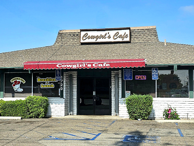 The classic Western facade of Cowgirls Cafe welcomes hungry travelers with its distinctive red awning and promise of home-style cooking.