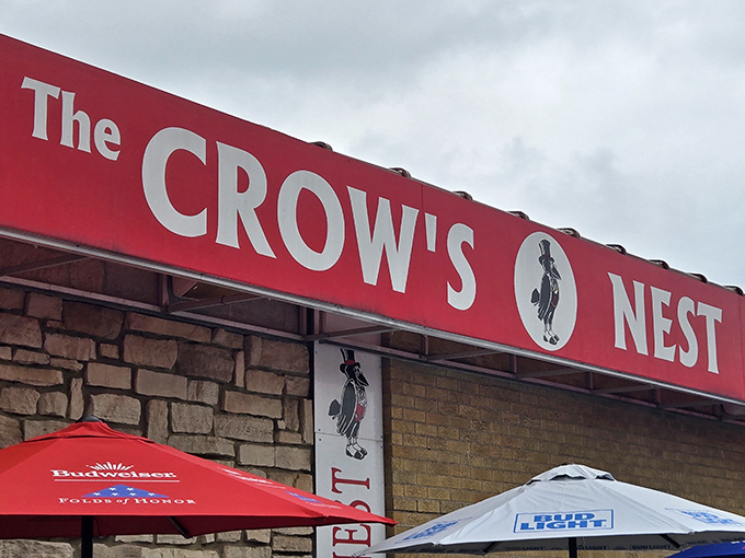 The stone facade and bright red awning of The Crow's Nest stands as a beacon to hungry travelers, even on rainy days when comfort food calls loudest.