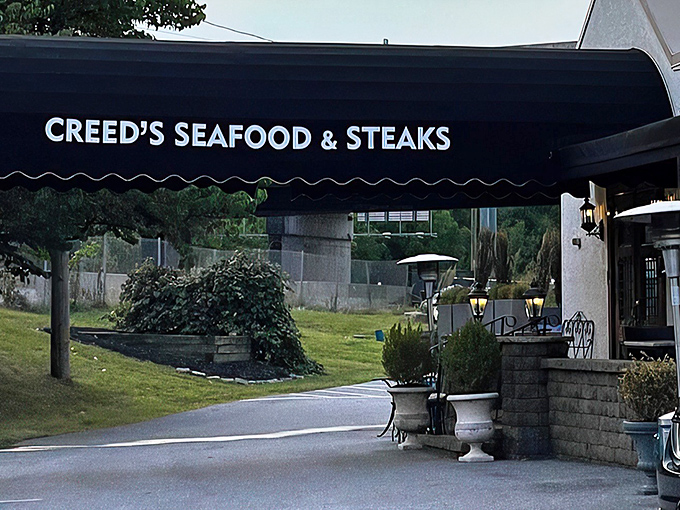 The classic black awning of Creed's welcomes you like an old friend who happens to know their way around a perfect seafood tower.