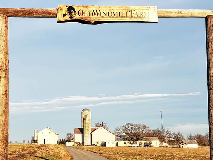 The iconic wooden entrance sign frames a postcard-perfect view of silos and farmhouses against Pennsylvania's endless sky.