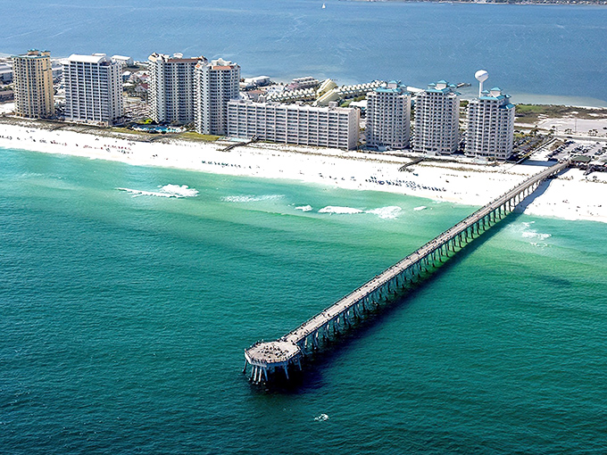 The emerald meets the sky: Navarre's iconic beachfront condos stand like sentinels guarding that famous fishing pier jutting into waters so blue they seem Photoshopped.
