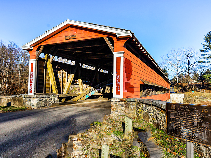 The vibrant red-orange exterior of Smith's Bridge stands like a portal to the past, inviting travelers to slow down and experience a slice of Americana.