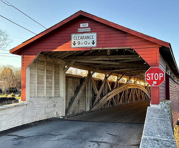 The iconic red exterior of Wehr Bridge stands as a bold declaration against time, its 9-foot clearance sign a gentle reminder of simpler, shorter transportation.