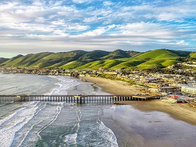 Pismo's iconic pier stretches into the Pacific like nature's welcome mat, while rolling green hills create a backdrop worthy of a desktop wallpaper.